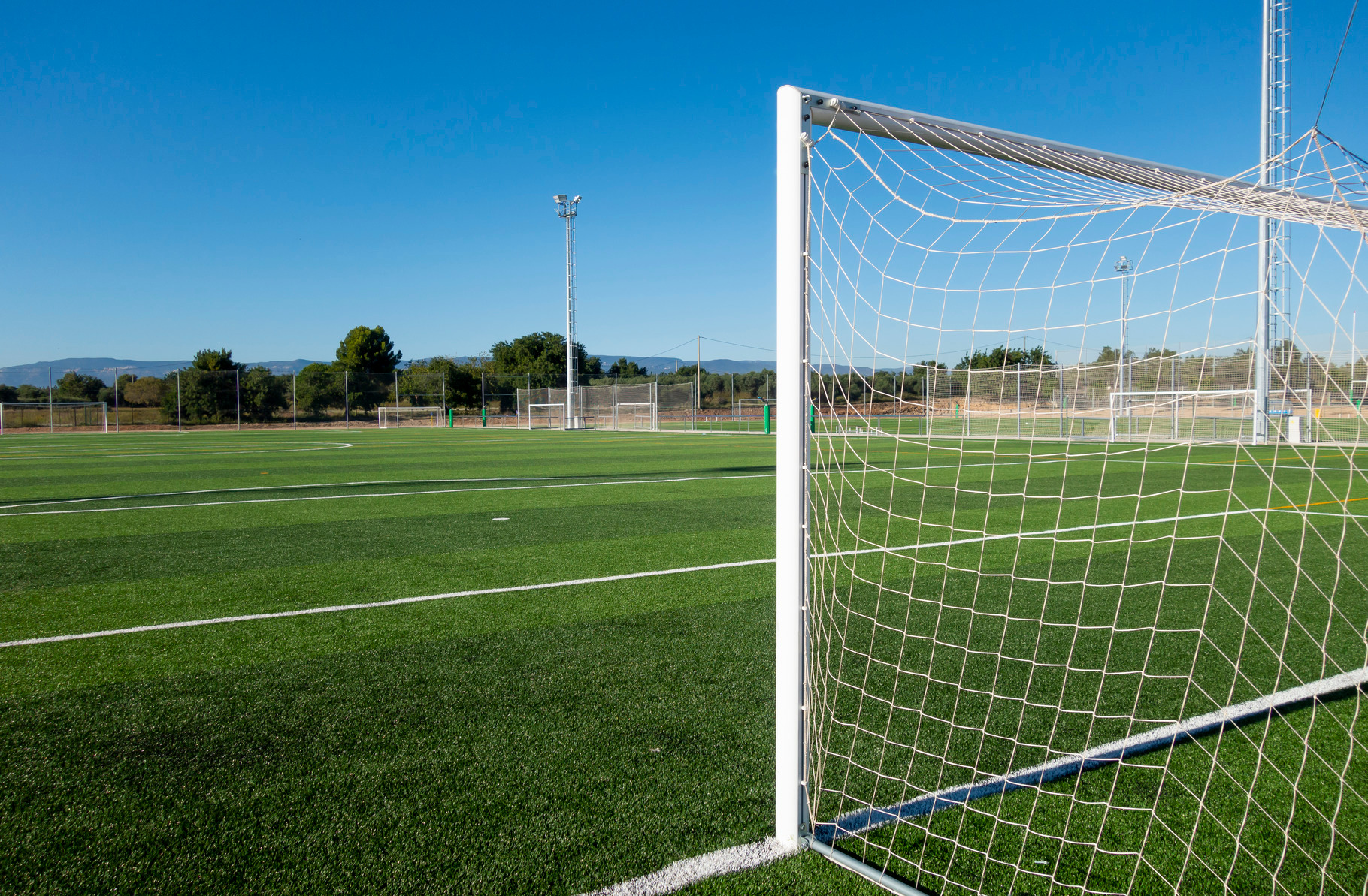 Football field in a sport complex containing soccer, net, and football ...