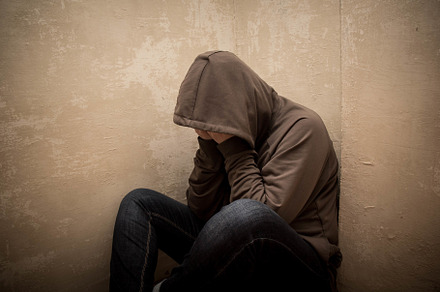 Portrait of man sad drug addict man sitting on the floor in corner ...