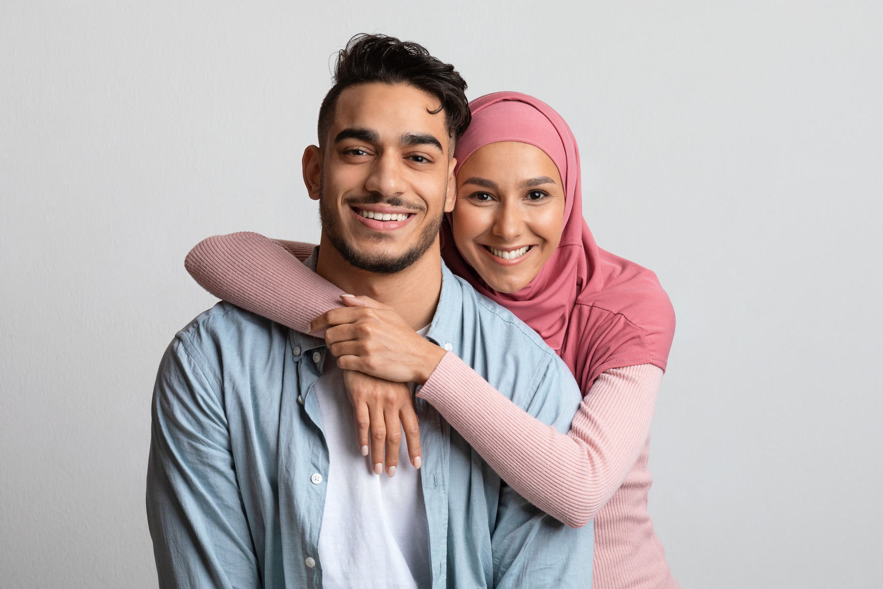 Portrait Of Muslim Couple Embracing Over Grey Background And Smiling At ...
