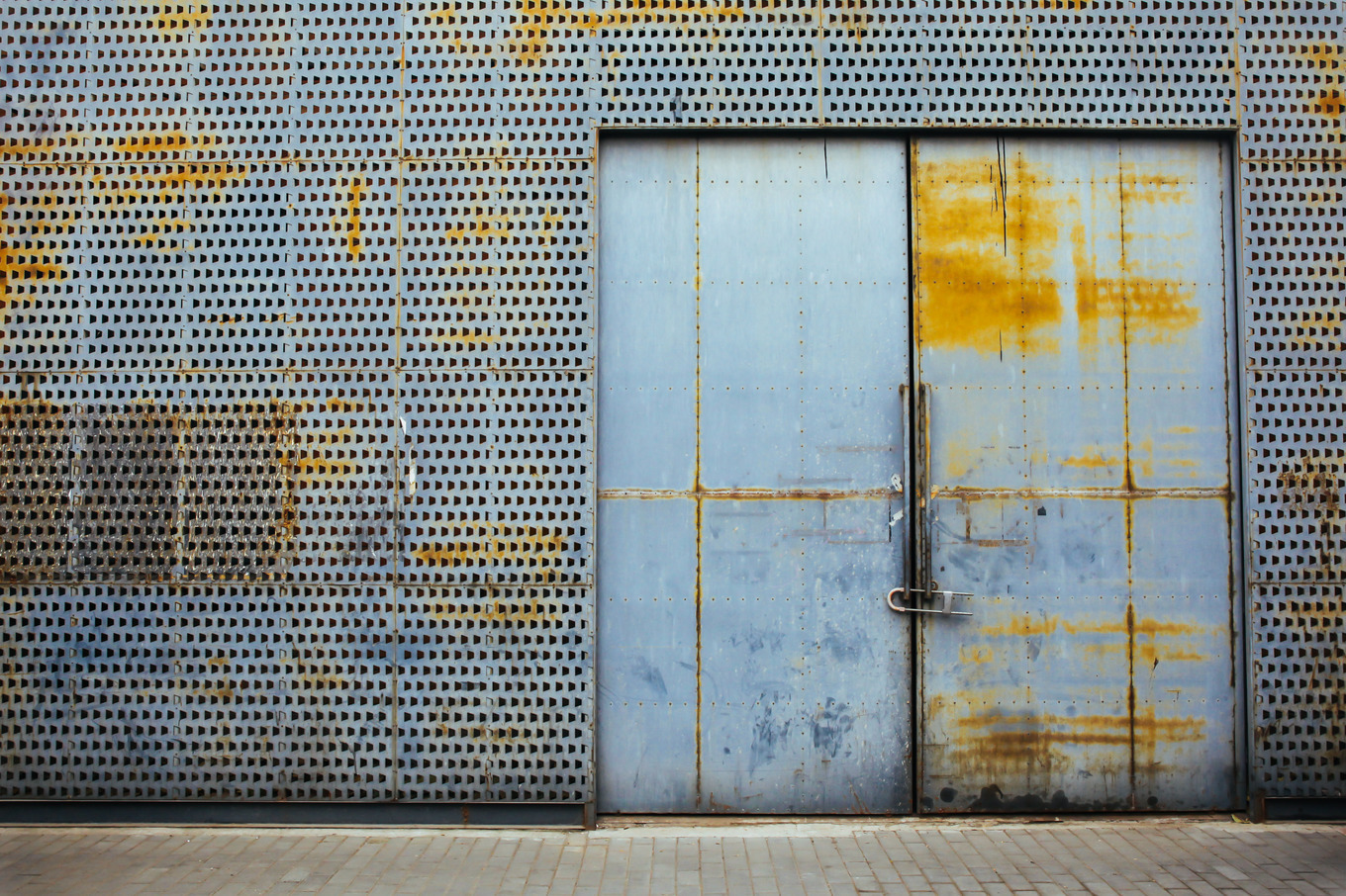 Rusty metal gate locked with security padlock and rusty metal wall ...