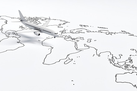 Plane flies above white paper map of the world travel background ...