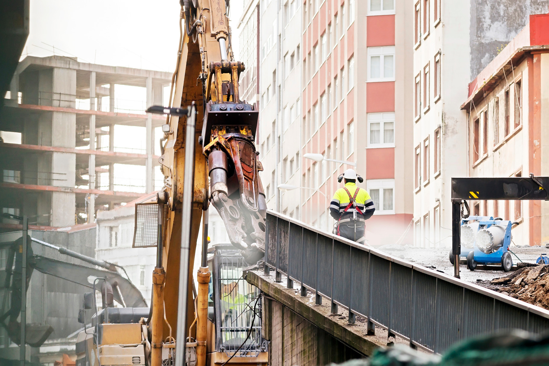 bridge destruction by demolition excavator with water fog cannon, an ...