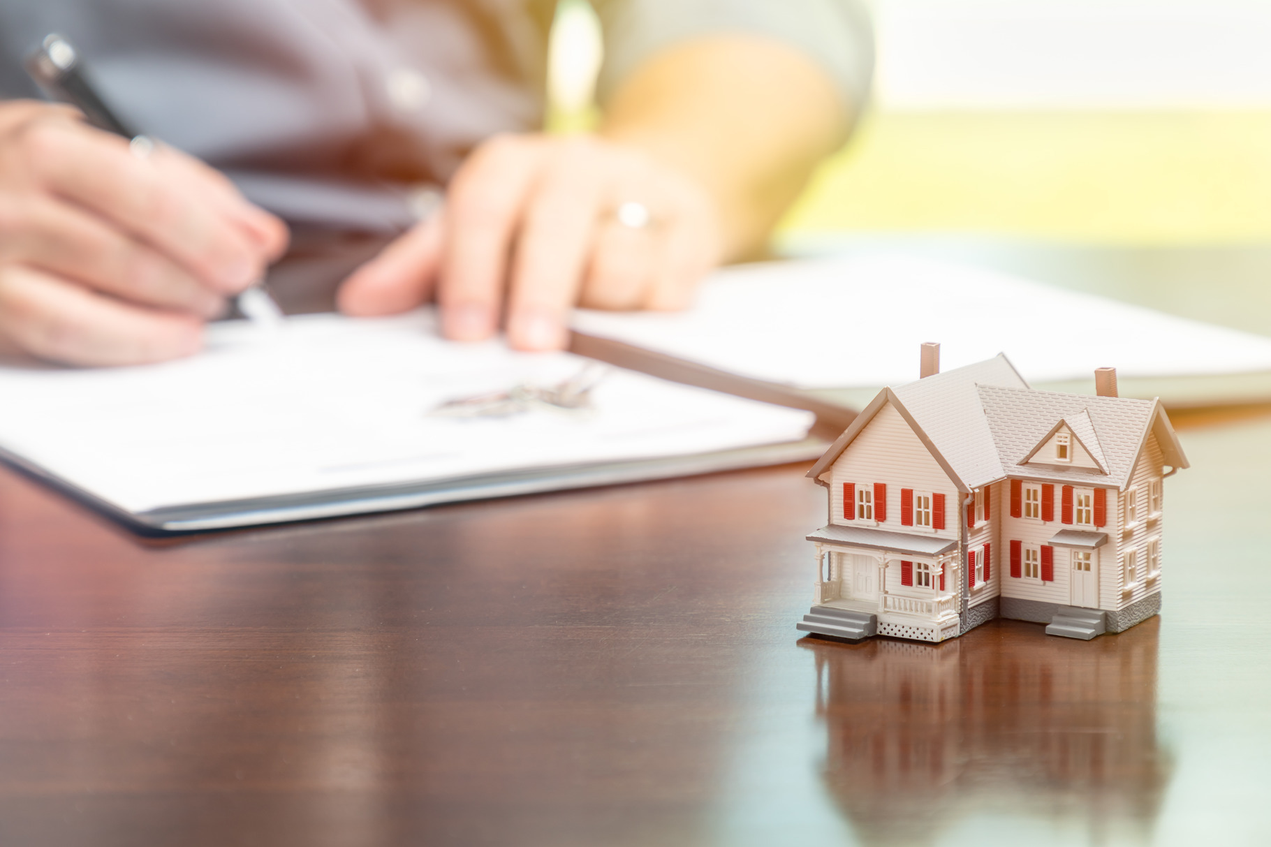 Man signing real estate contract, a Photo by Andy Dean Photography