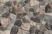 A textured wall made of various sizes and shapes of natural stones ...