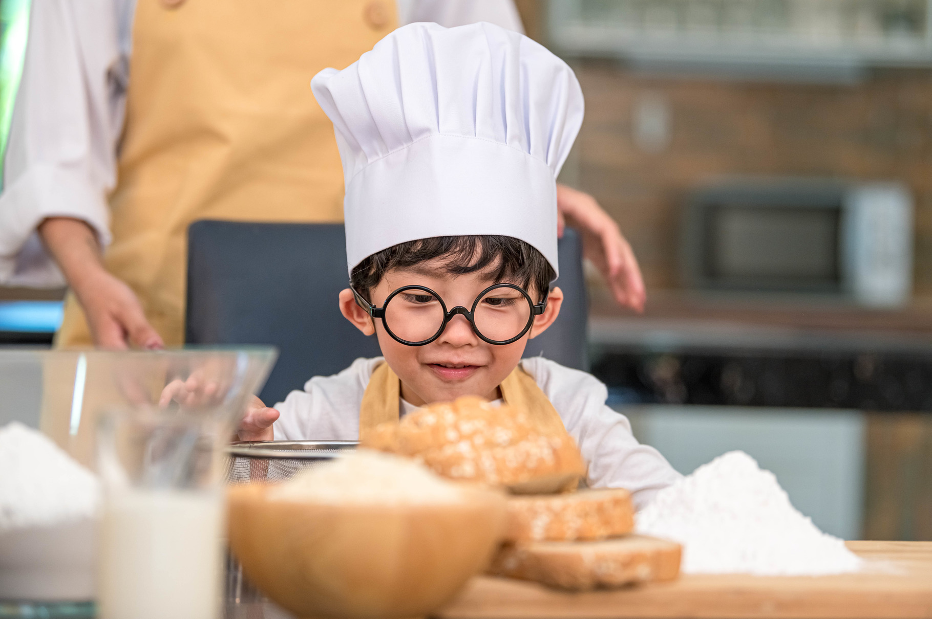 Portrait cute little Asian happy boy interested in cooking funny ...