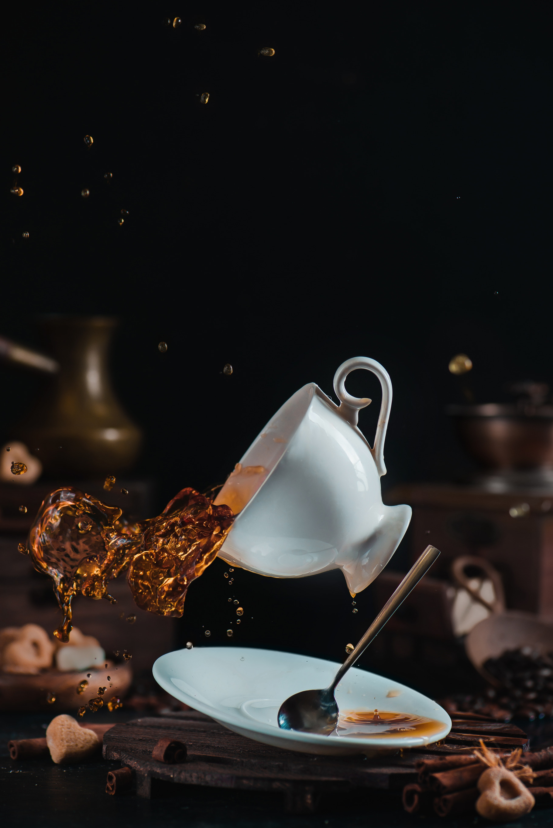 Falling coffee cup with a dynamic splash in a dark scene with cezve ...