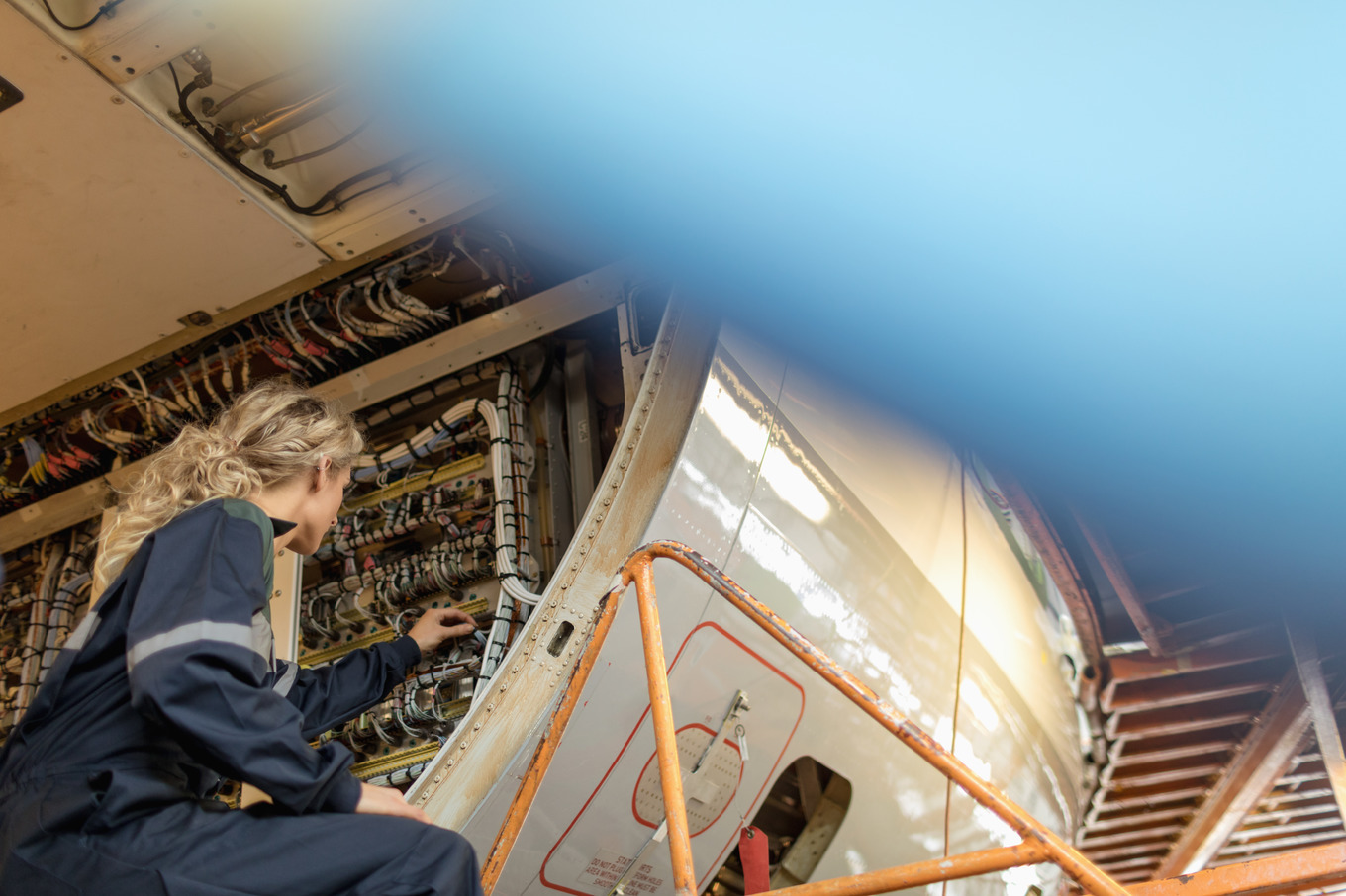 Female aircraft maintenance engineer working over an aircraft engine, a ...