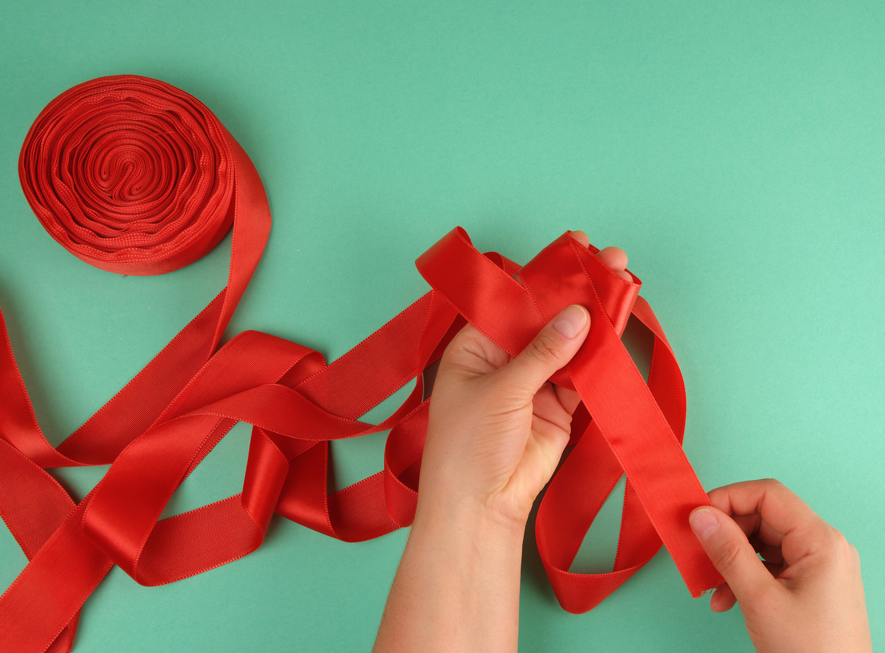 Two female hands and red silk ribbon featuring hand, hold, and concept ...