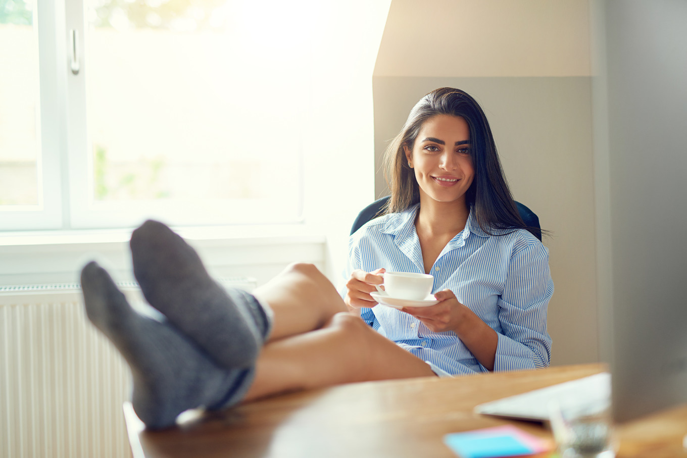 Beautiful woman sitting with feet on desk, a Person Photo by Stefan & Janni