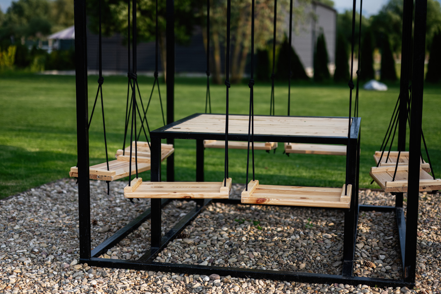Outdoor seating area with swings on gravel in a green garden, a Photo ...