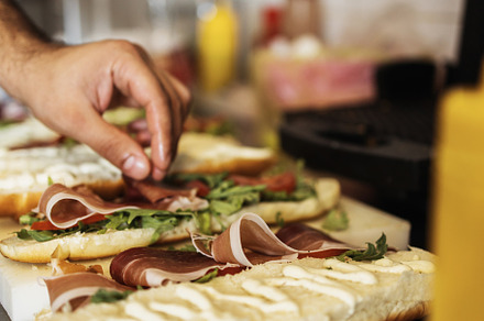 Woman cooking using the computer to watch virtual culinary class, a ...