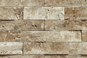 Textured stone wall made of rectangular beige travertine tiles ...