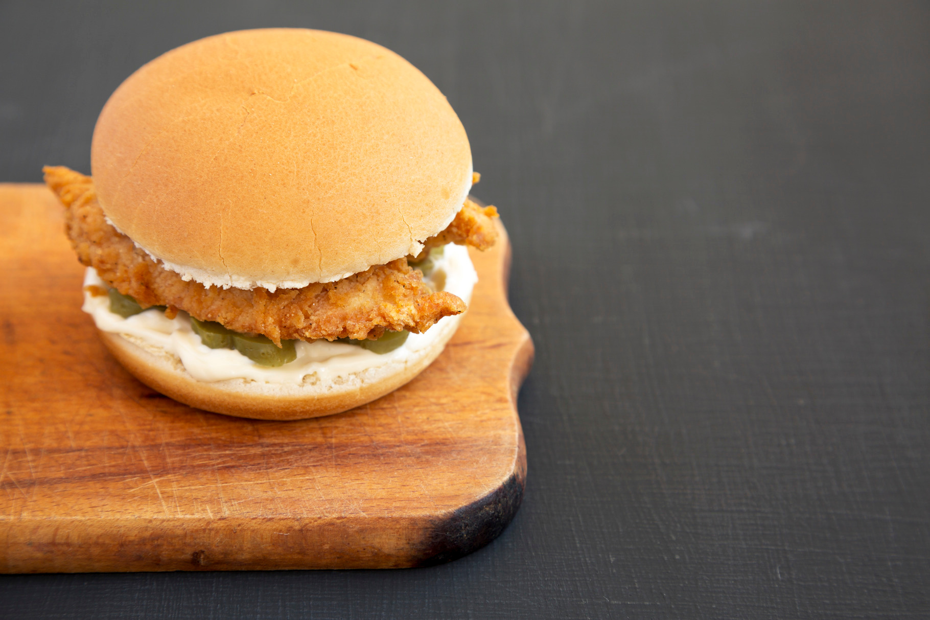 Homemade Burger with fried chicken strips on a rustic wooden boa, a ...