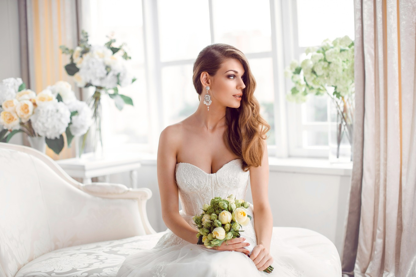 Bride in beautiful dress sitting resting on sofa indoors featuring ...