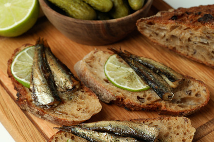 Board with sandwiches with sprats on white background, a Food & Drink ...