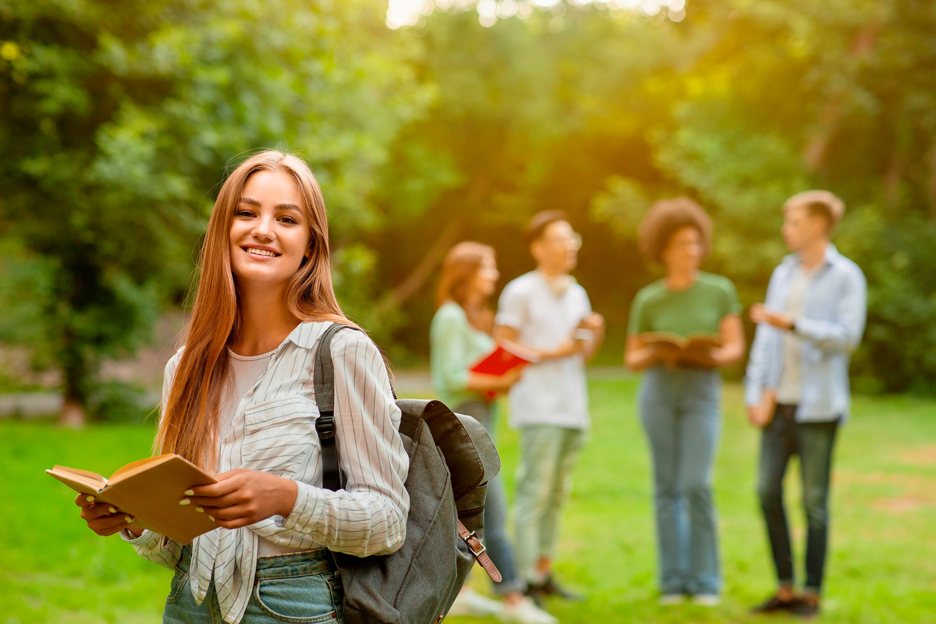Happy smiling student girl holding b, a Background Photo by Prostock-Studio