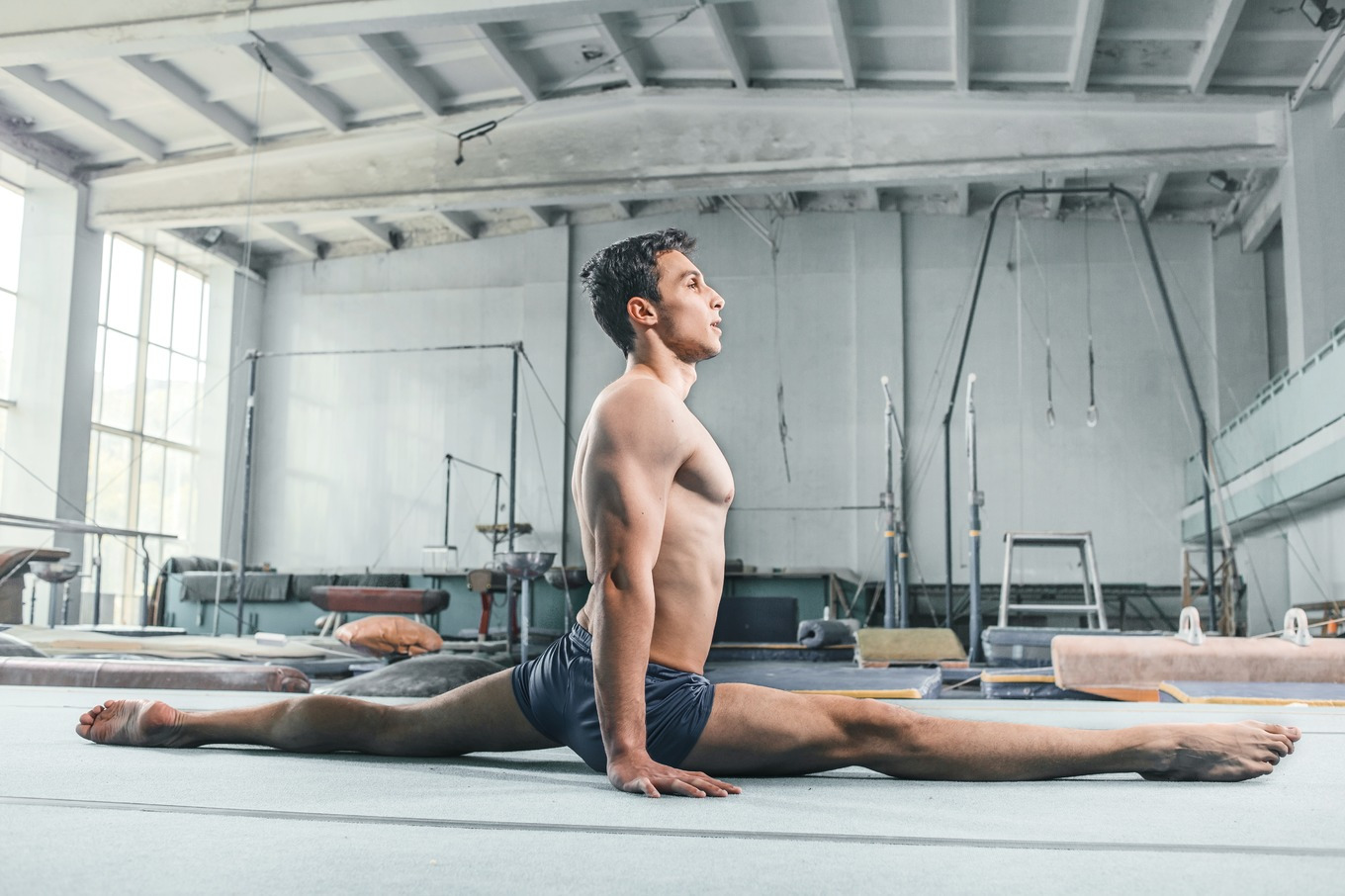 Caucasian man gymnastic acrobatics equilibrium posture at gym ...