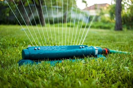 close up automatic system of water splinker pouring green lawn in the ...