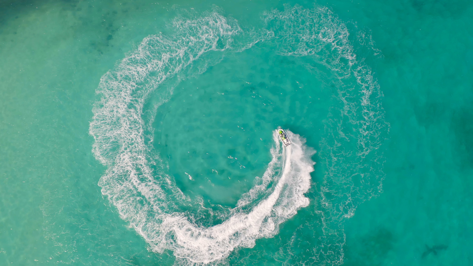Aerial top view of jet ski or boat drawing a shape on sea ocean, a ...