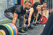 Mixed team lifting weights in the gym with their coach, a Sports ...