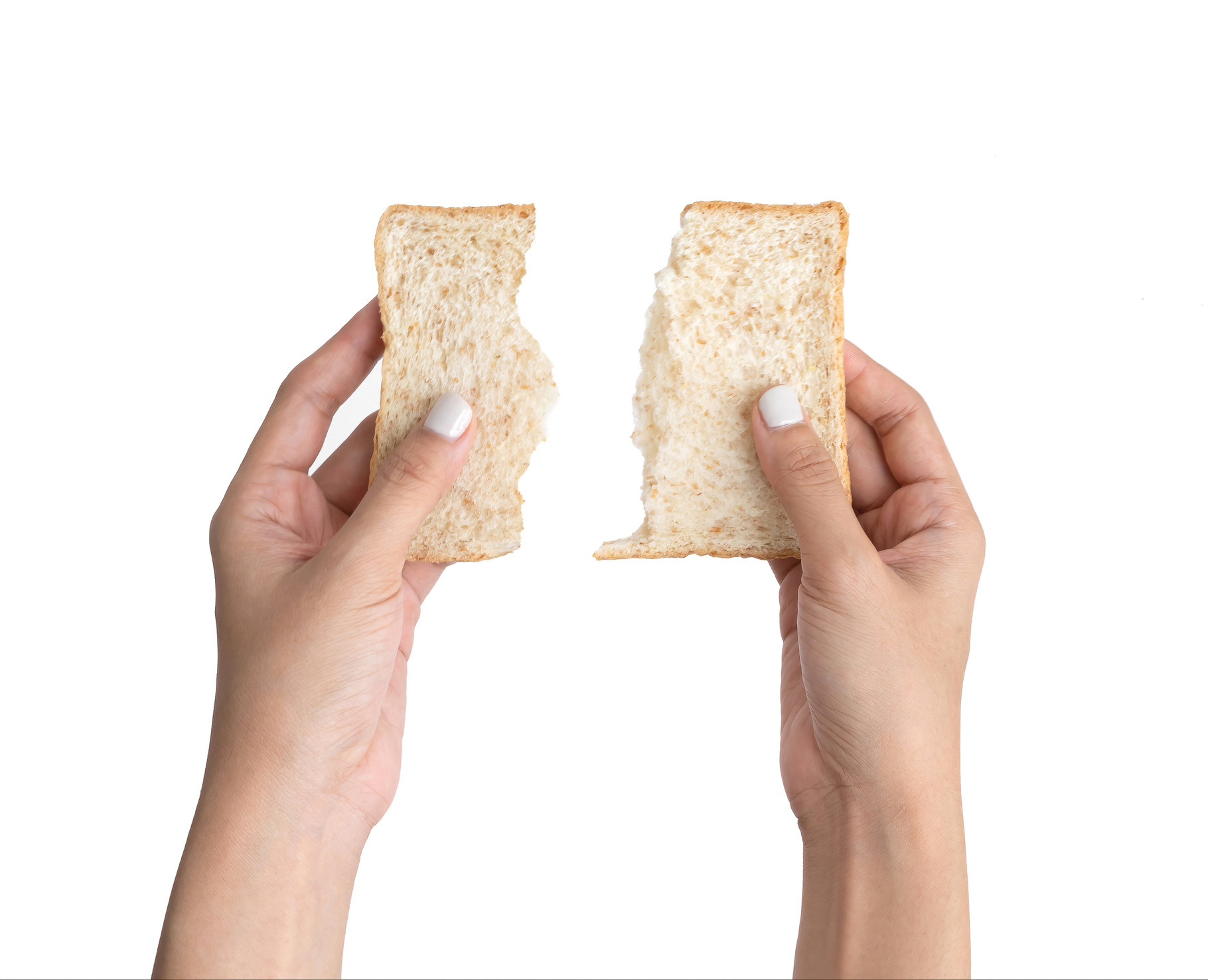 Hands tear off a slice of wholewheat bread isolated on white bac, a ...