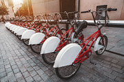 Red rental cycles in urban settings, a Transportation Photo by SkyNext