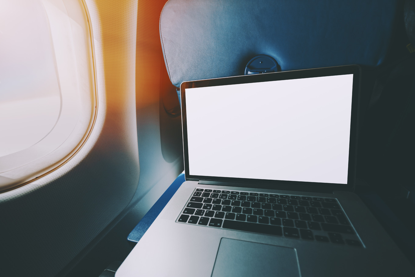 Laptop with blank screen in plane, a Transportation Photo by SkyNext