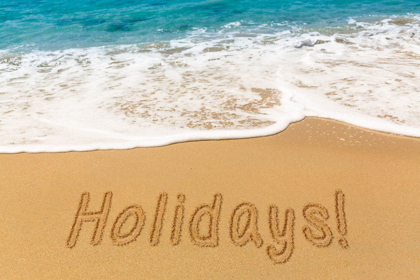 Sand writing Holidays on beach, a Holiday Photo by Backyard Stock