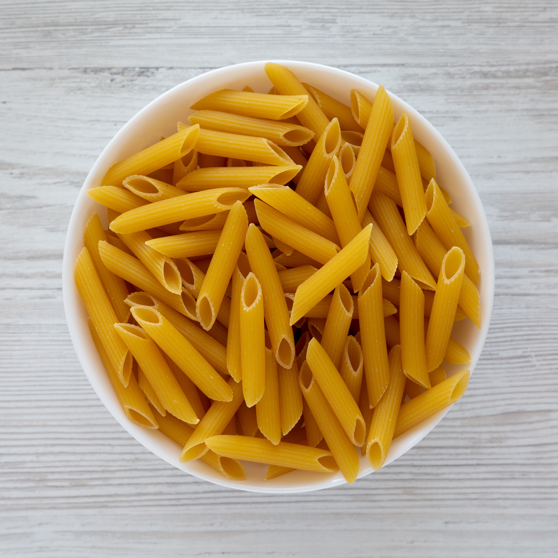Homemade Raw Dry Penne Pasta in a White Bowl, top view. Flat lay | Food ...