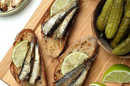 Board with sandwiches with sprats on white background, a Food & Drink ...