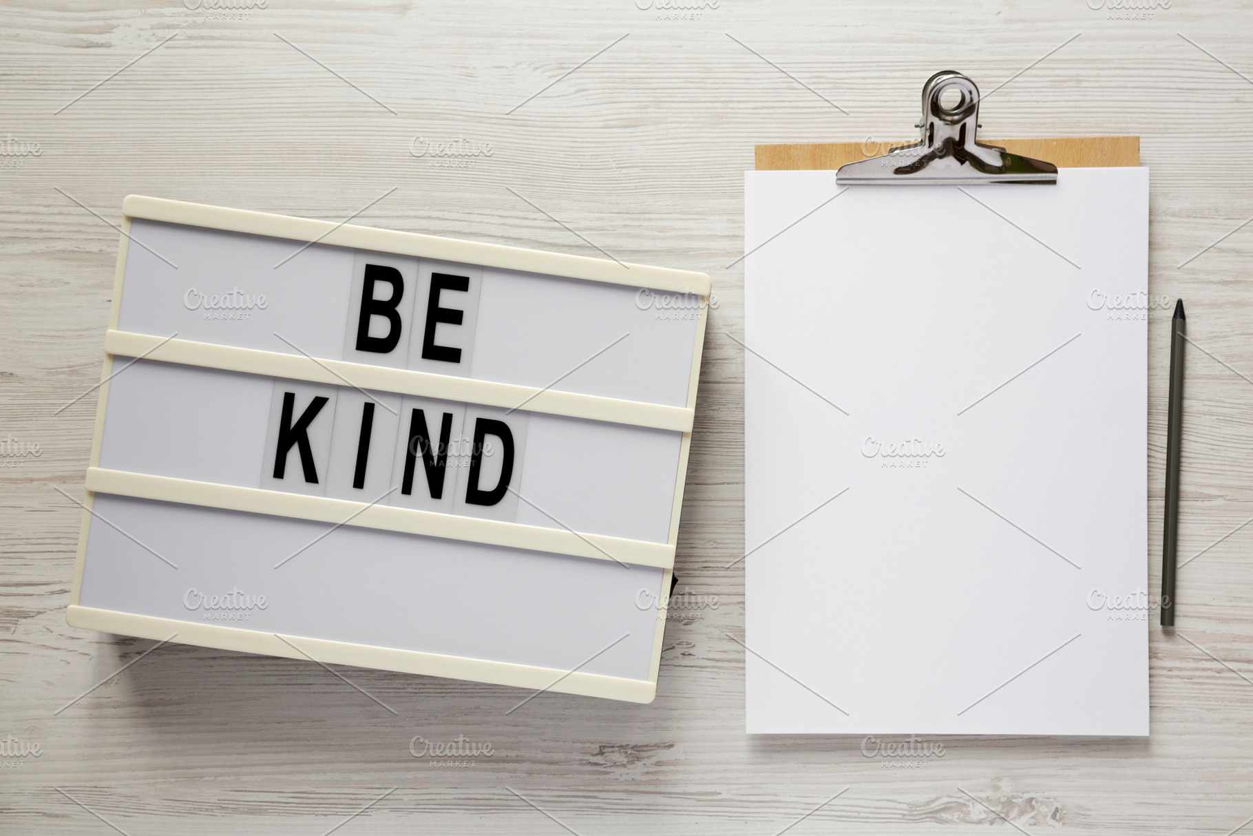 'Be kind' on a lightbox, clipboard with blank sheet of paper on, a ...