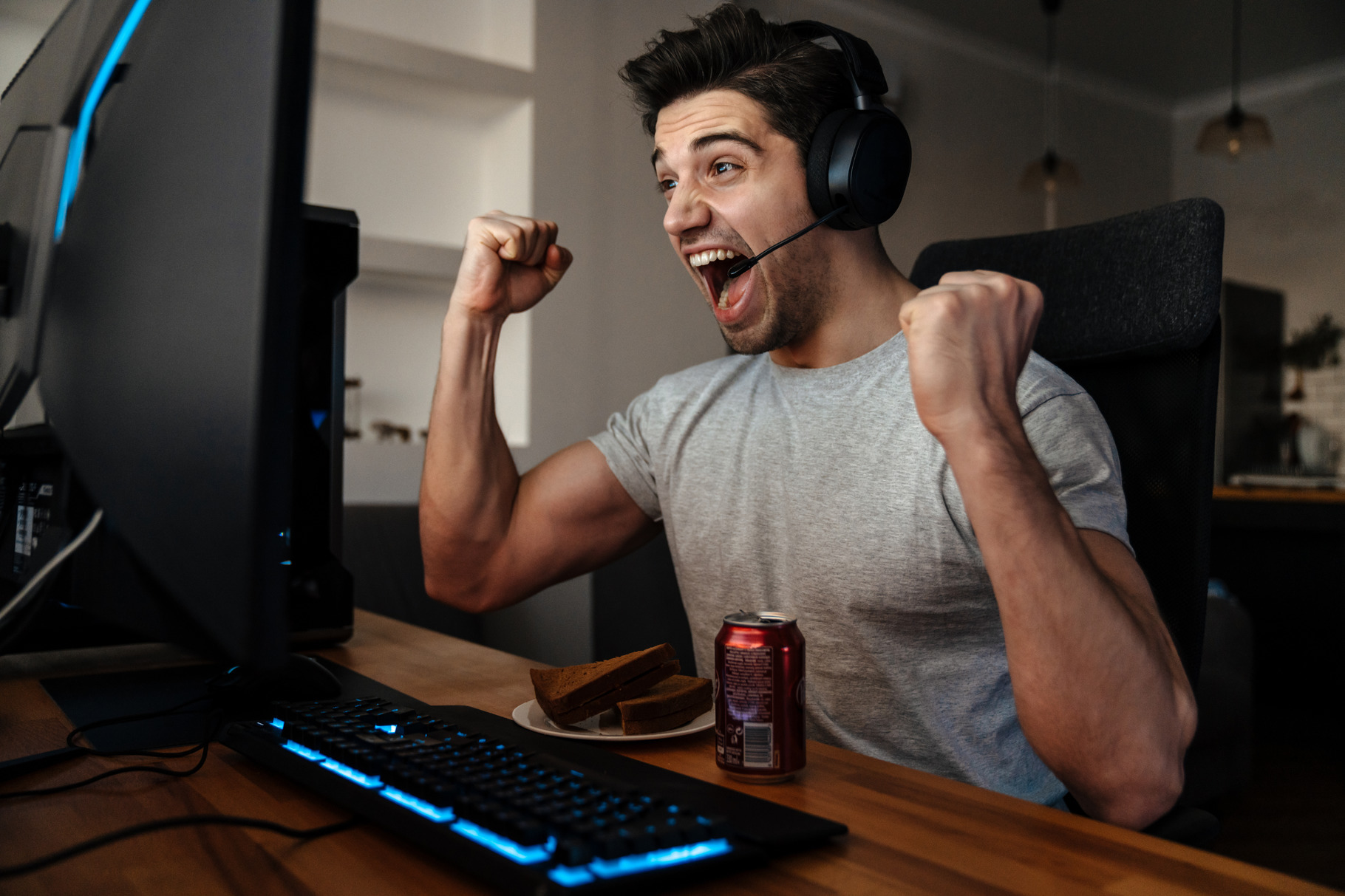 Excited guy making winner gesture while playing video game on computer ...