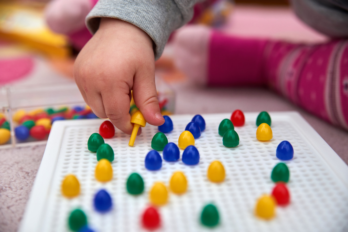 toddler plays with colorful pins | Arts & Entertainment Stock Photos ...