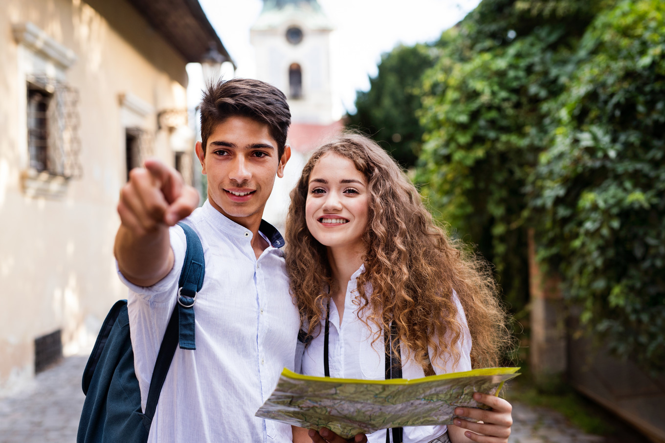 Two young tourists with map and camera in the old town featuring man ...