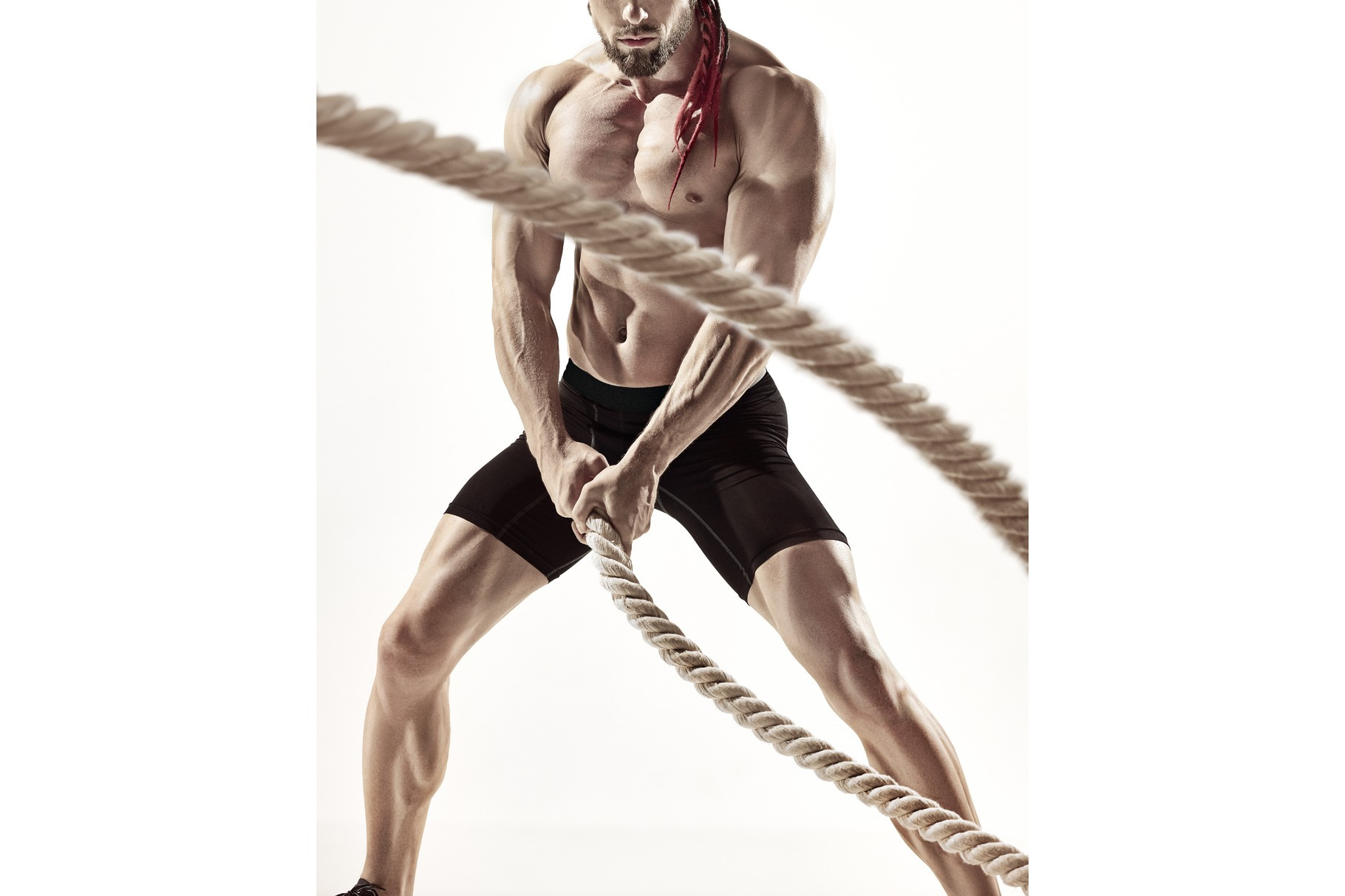 Attractive muscular man working out with heavy ropes featuring fit ...