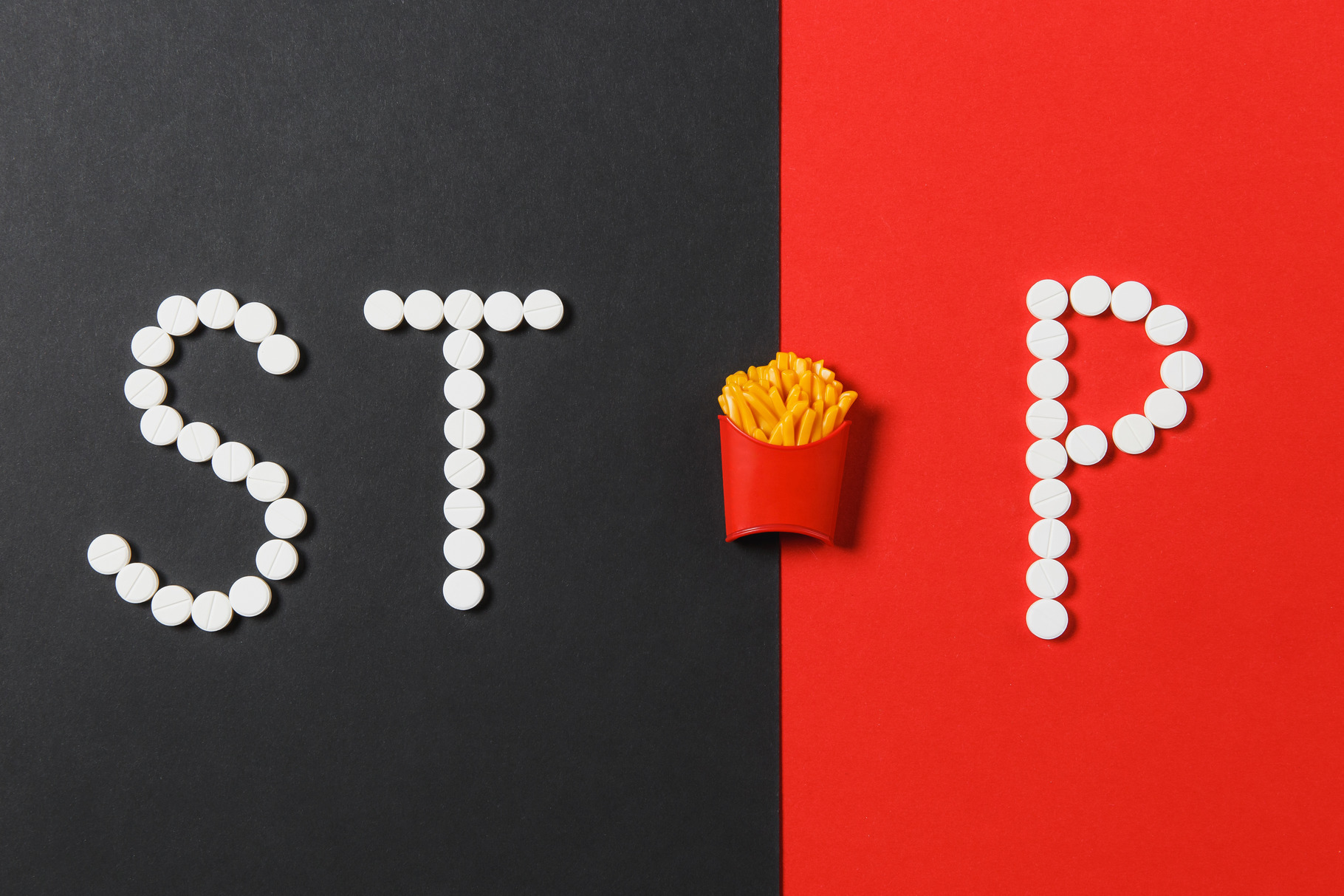 Headline No fast food. Medication white round tablets in word Stop, box ...