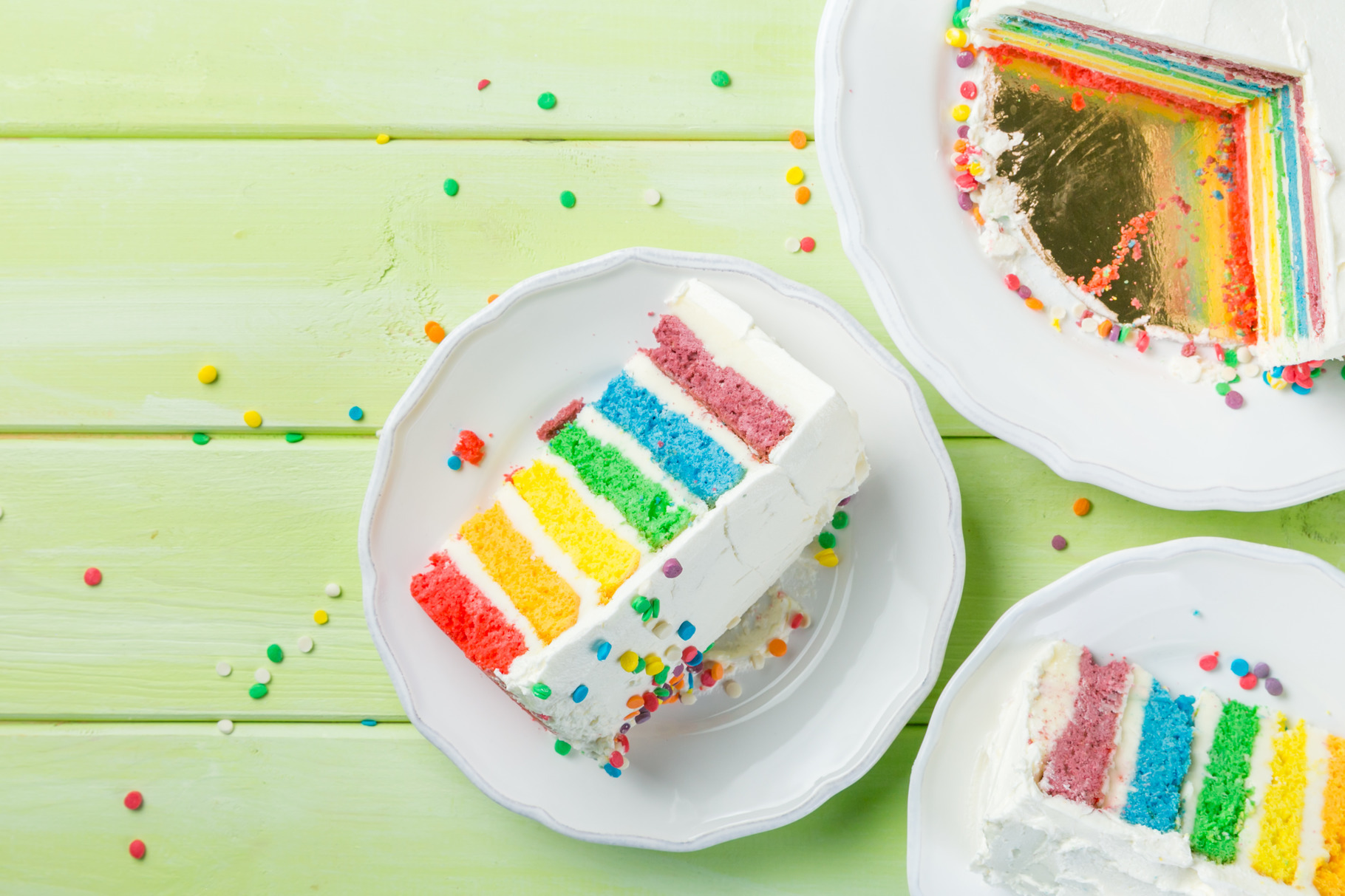 Birthday background striped rainbow cake with white frosting containing ...