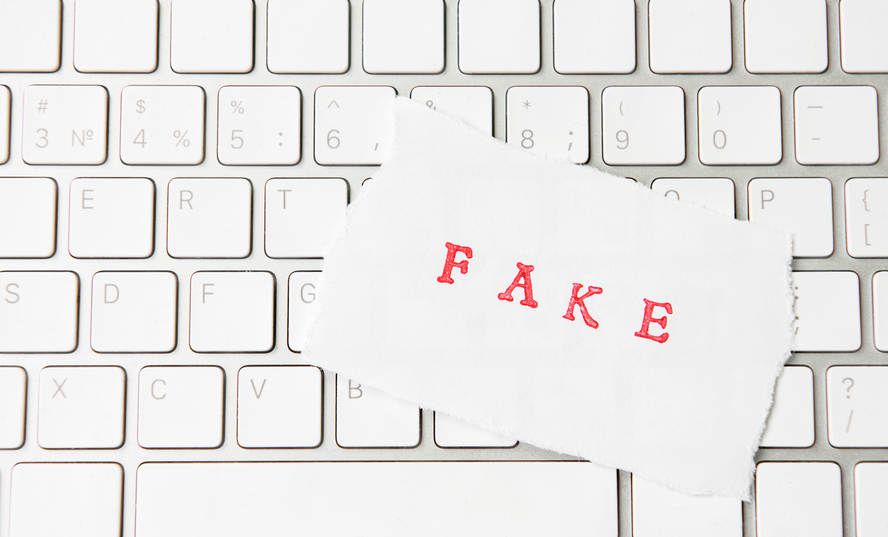 Word fake written on torn paper containing fake news, manipulation, and ...