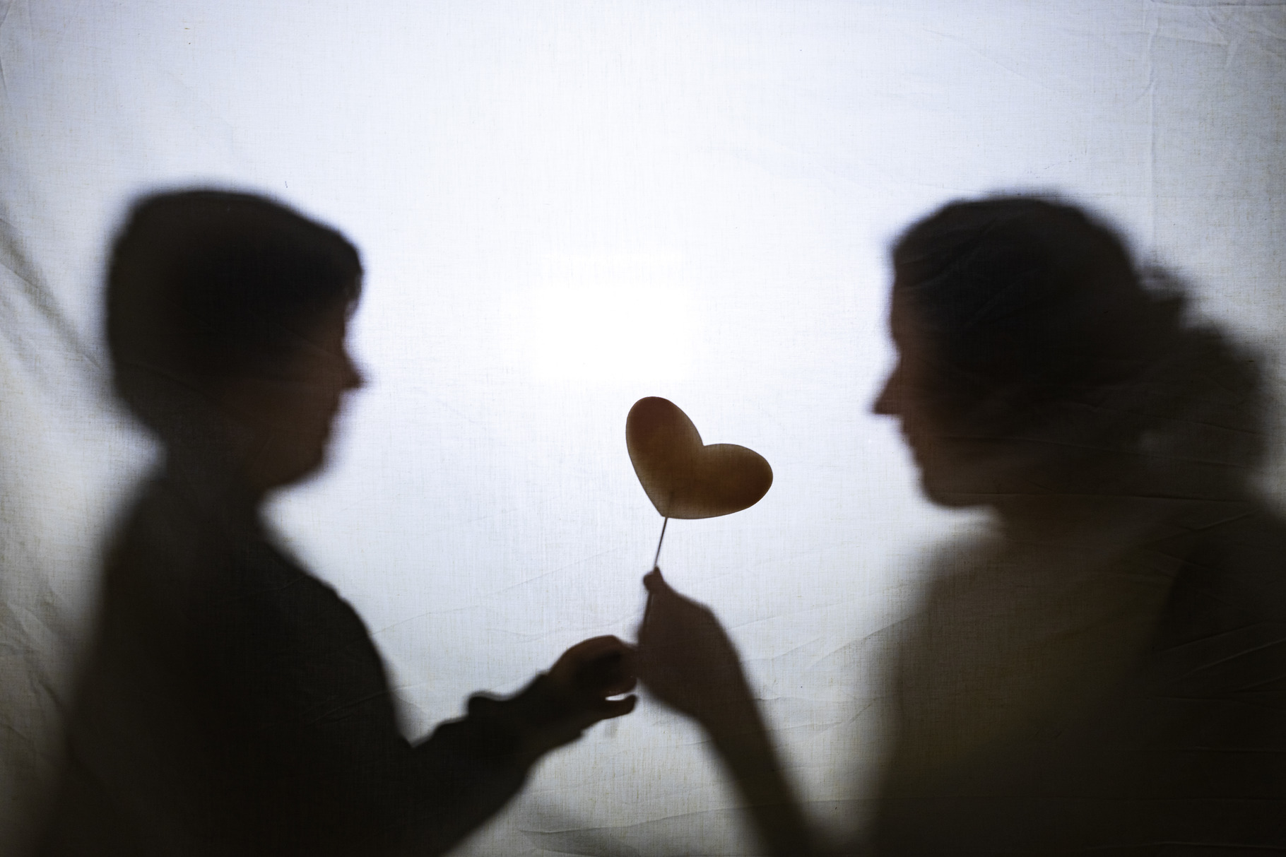 Mother and son playing with shadows behind a bed sheet | People Images ...