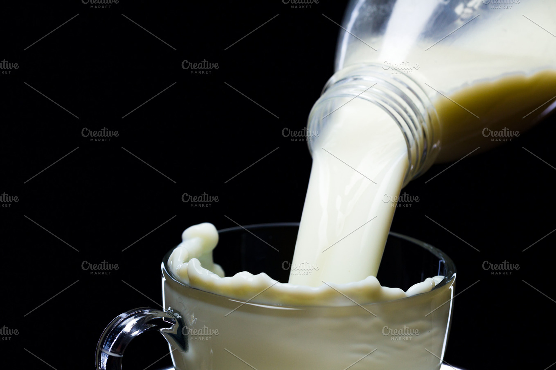 Milk pours into glass ware on a black background featuring milk, drink ...