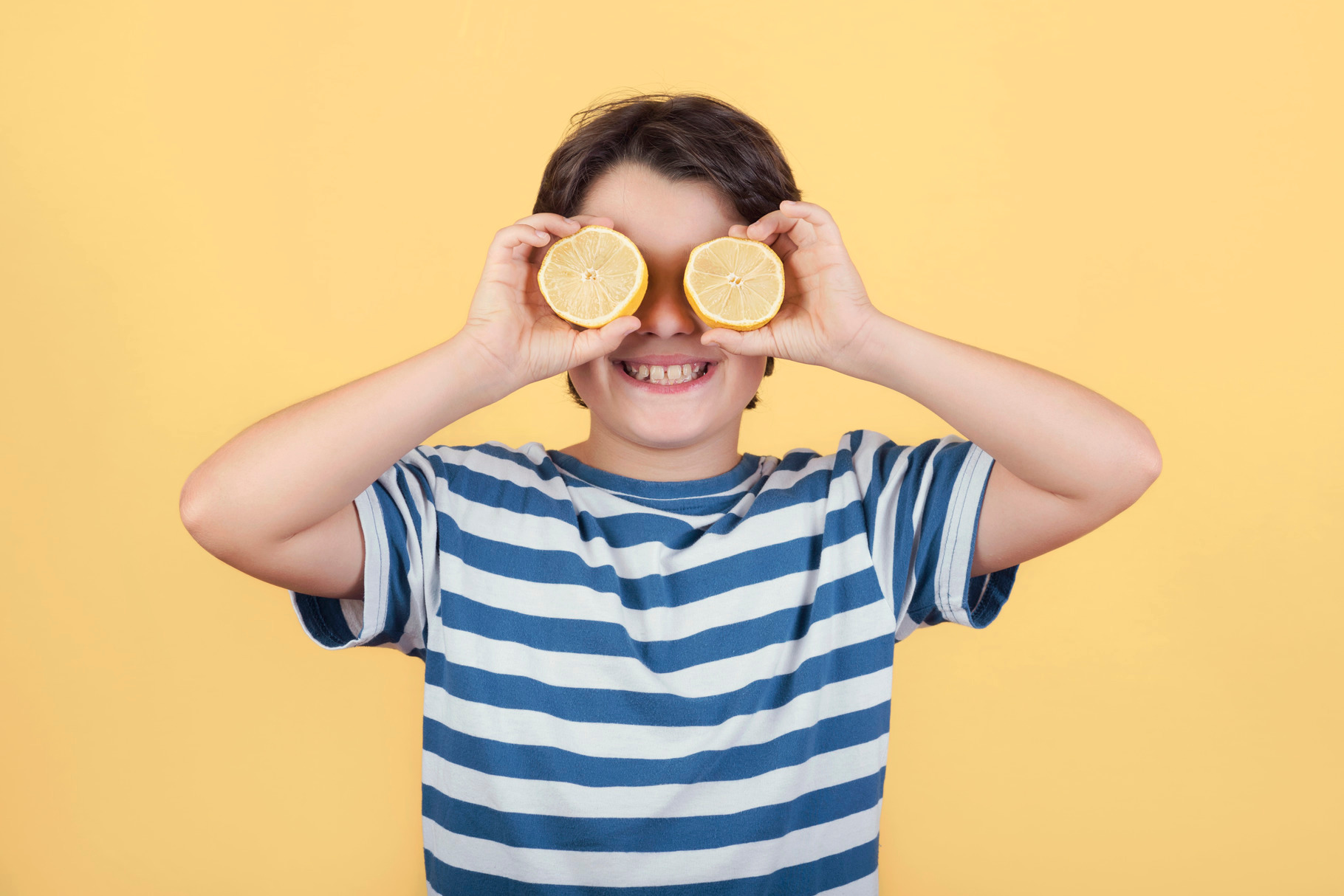 child holding lemons over her eyes, a Person Photo by esthermm