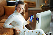 Woman and radiator using smartphone featuring radiator - heater, winter ...