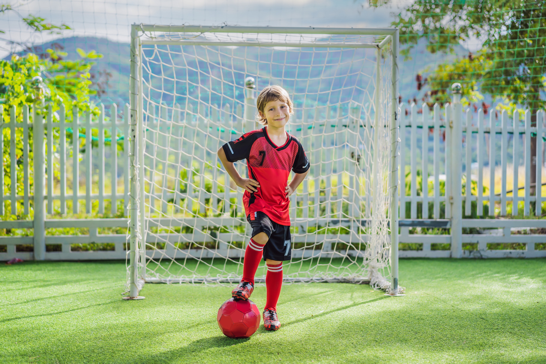 Little cute kid boy in red football containing boy, football, and field ...