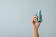 Female hand holds asthma inhaler on light gray background, a Health ...