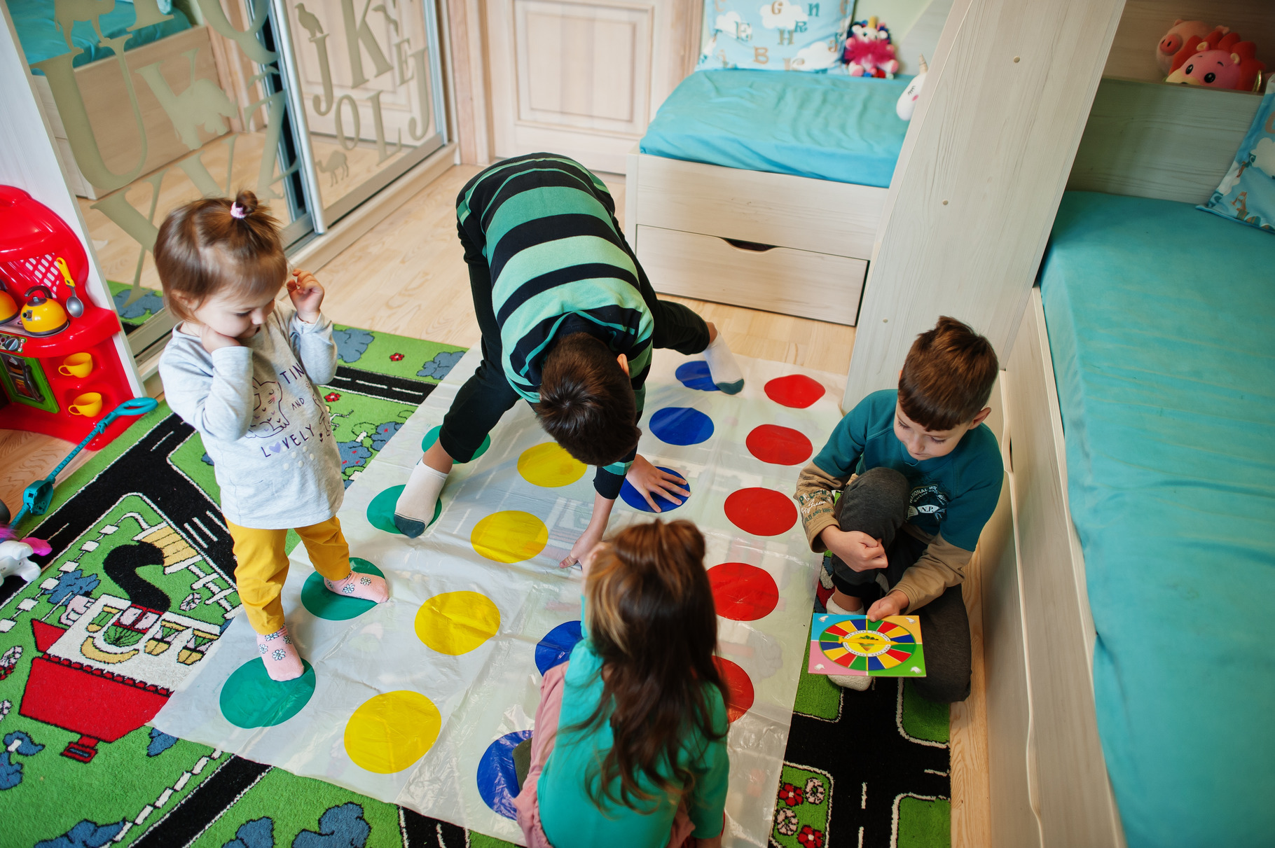 Happy family having fun together,four kids playing twister game, a ...