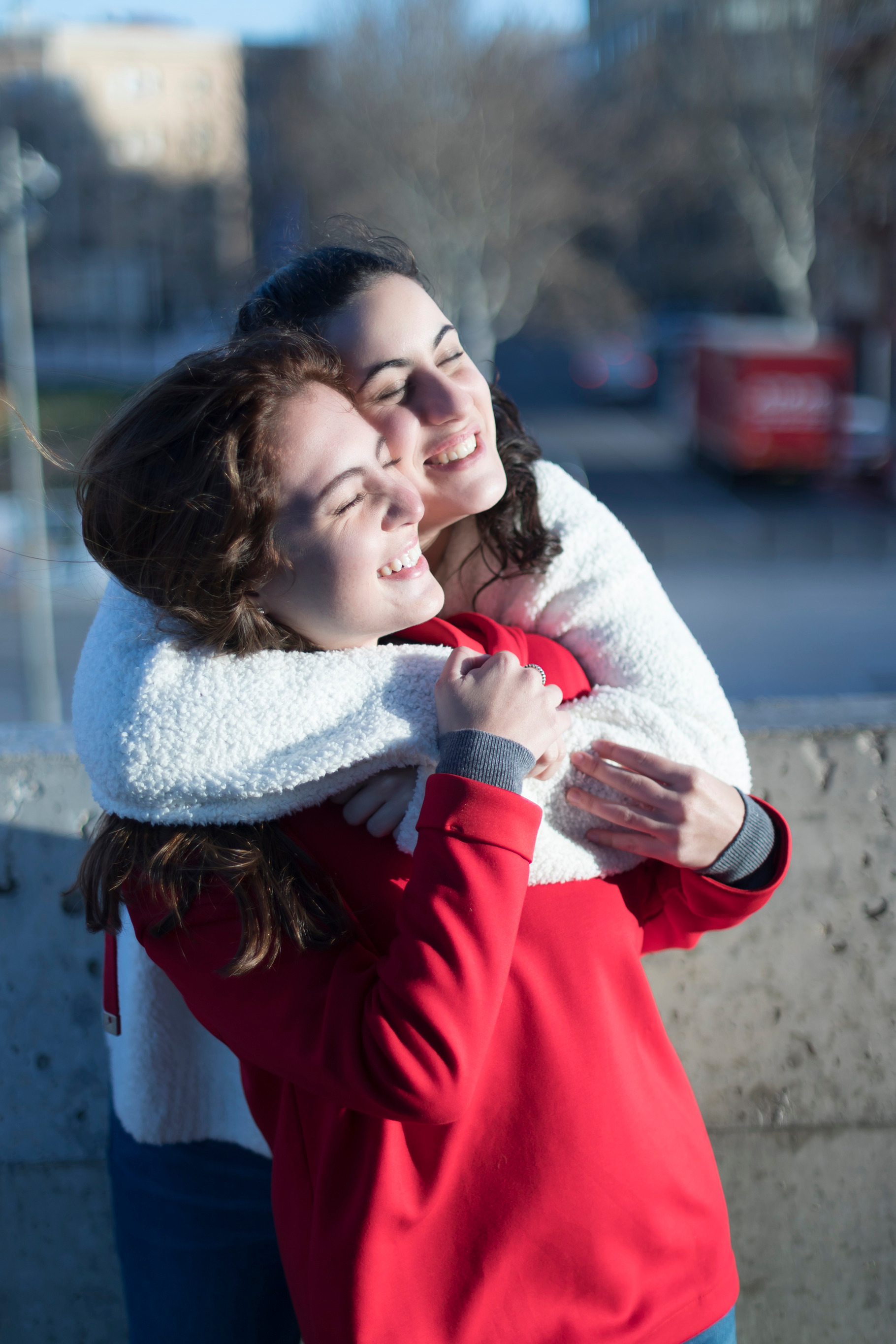 Joyful hug between two friends outdoors, a Person Photo by RF Images
