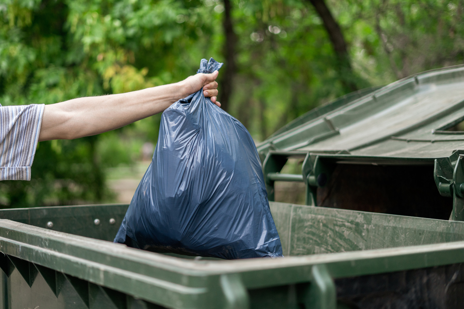 male dumping waste package into a bi | Stock Photos ~ Creative Market