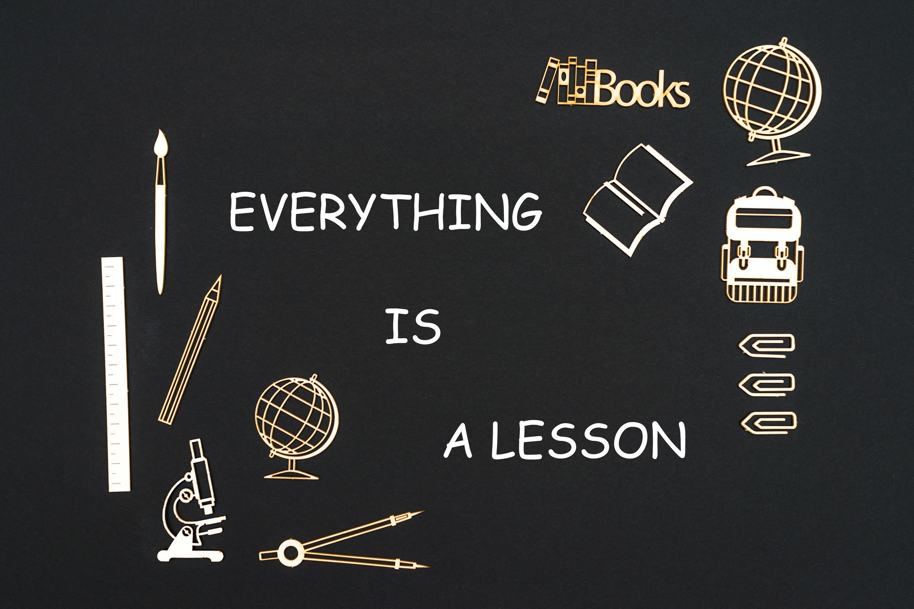 School supplies placed on black background with text everything is a ...