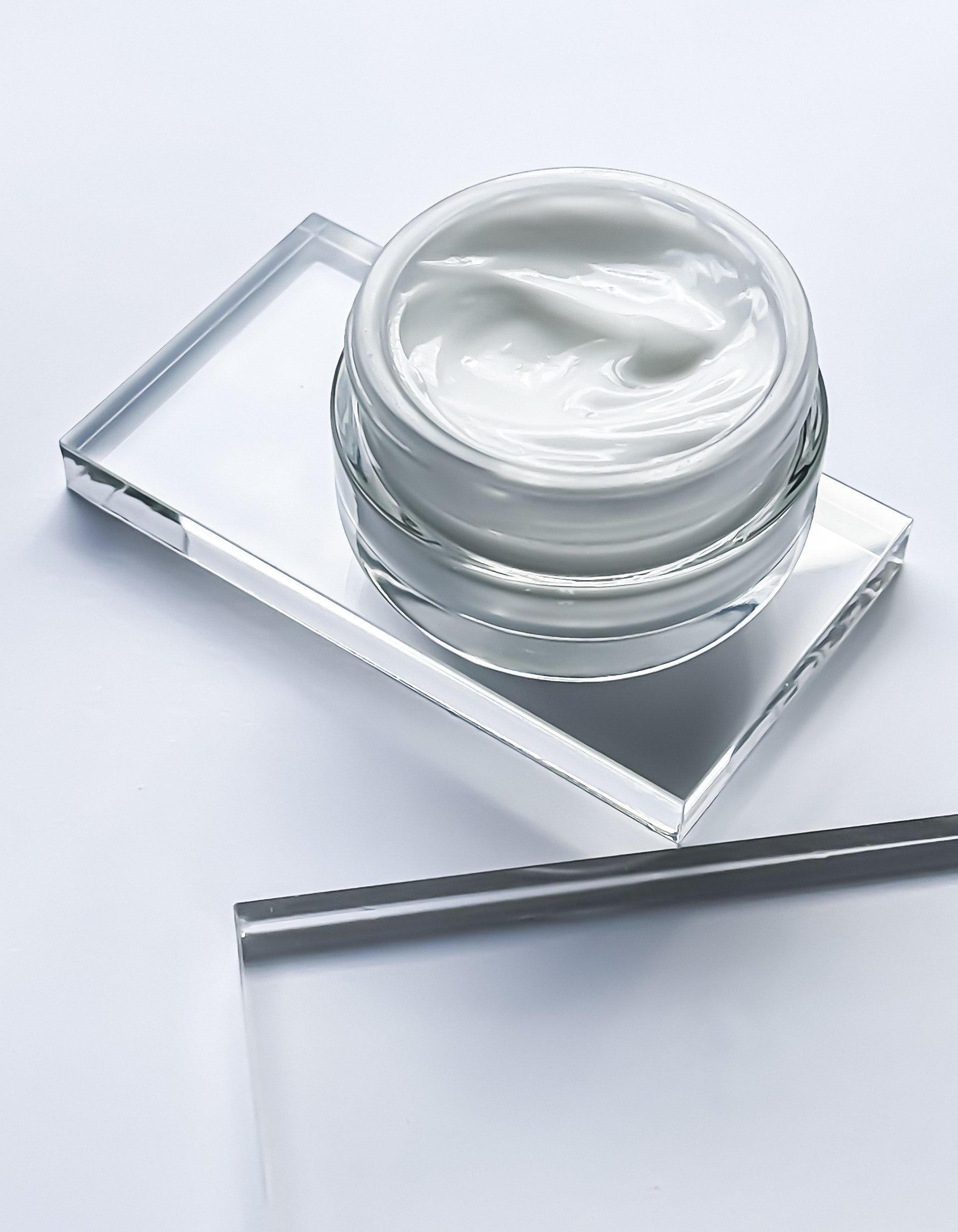 Face cream moisturiser jar and product sample on glass, beauty a ...