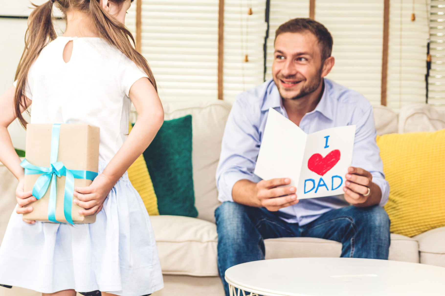 Little daughter giving her father a featuring gift, father, and girl, a ...